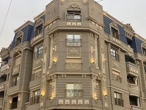 Um edifício de vários andares com detalhes arquitetônicos elaborados, incluindo molduras decorativas e varandas com grades de ferro forjado.