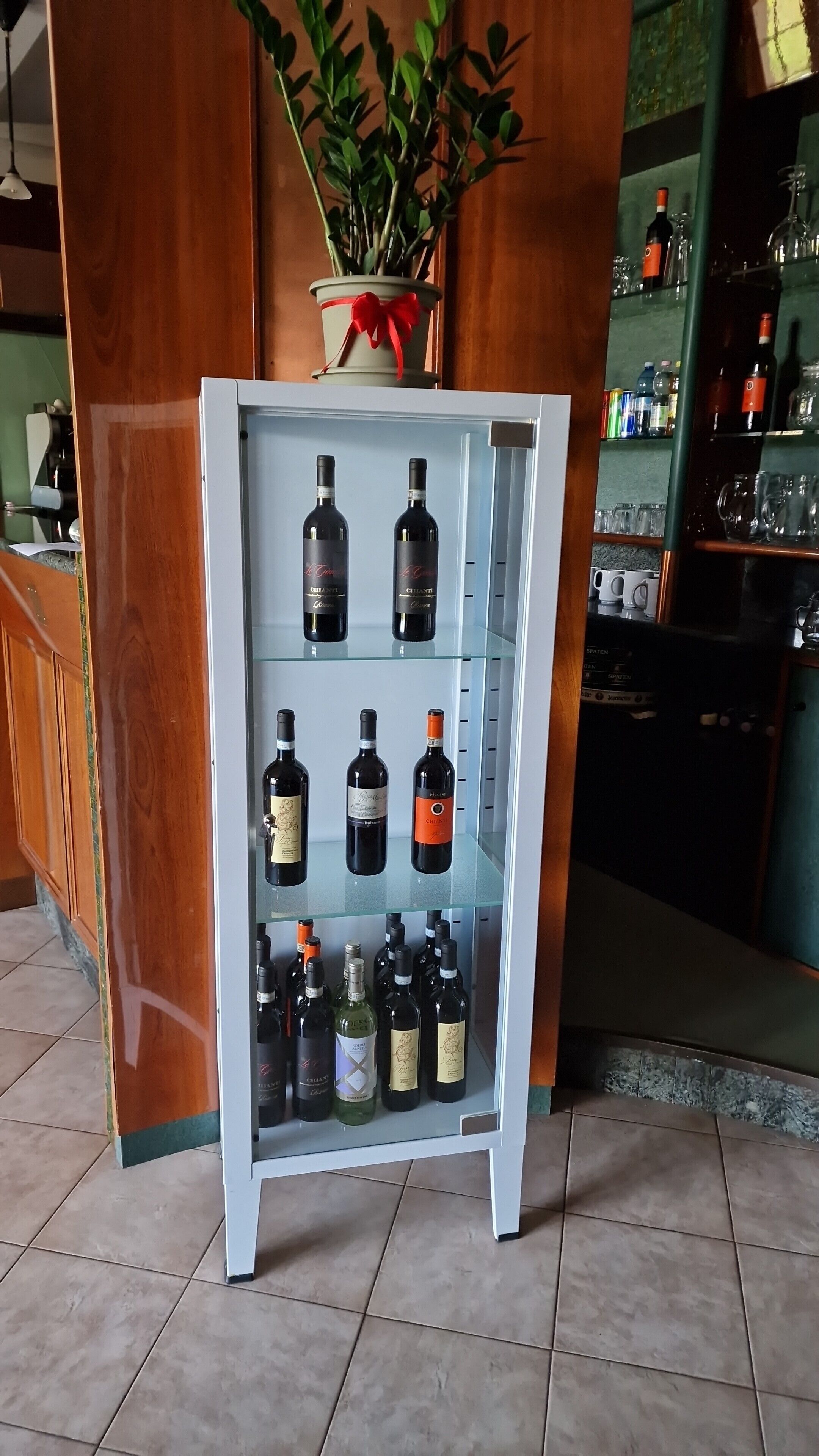 Um frigorífico para vinho com várias prateleiras, cada uma com diferentes garrafas de vinho.