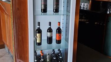 Um frigorífico para vinho com várias prateleiras, cada uma com diferentes garrafas de vinho.