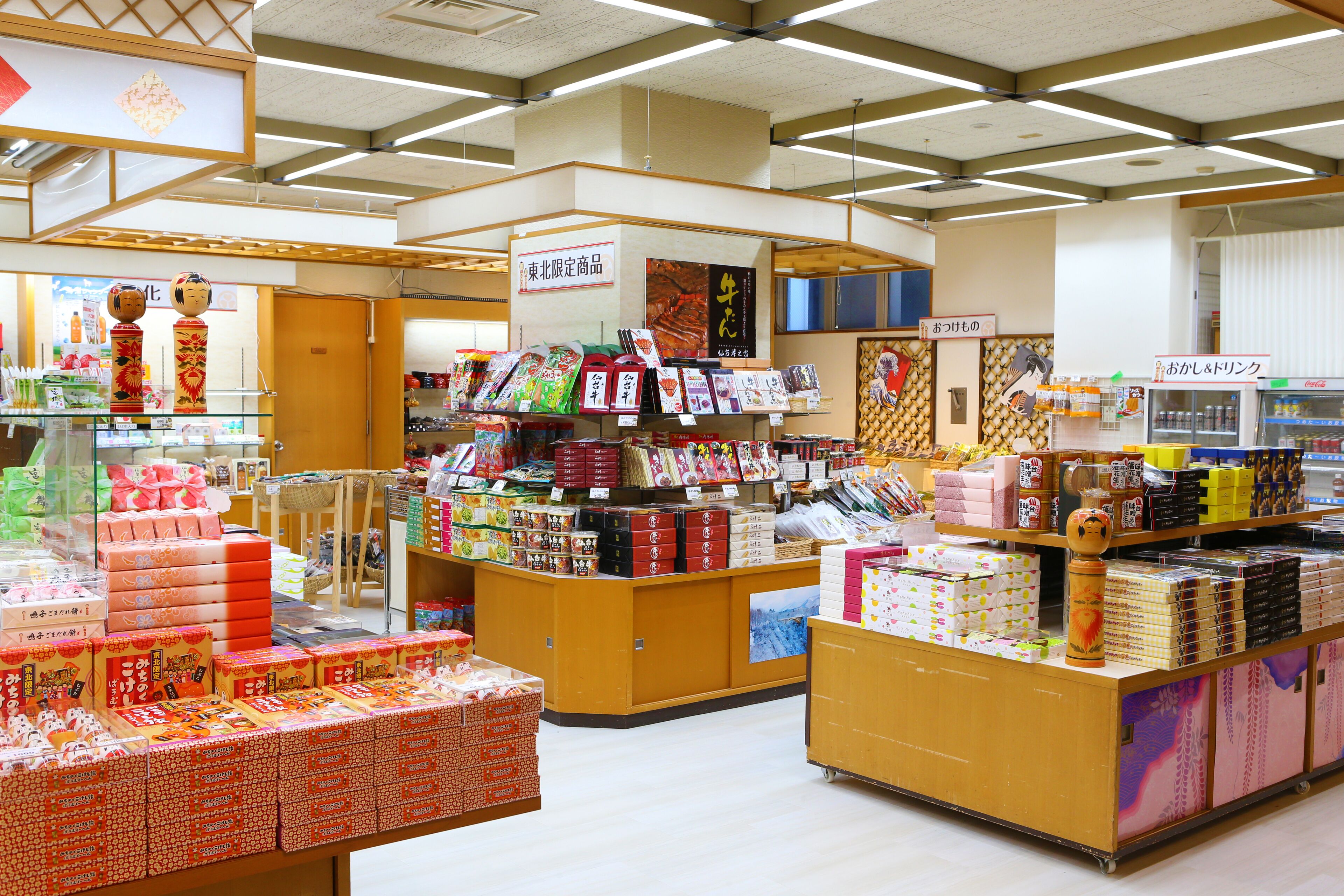 Loja com diversos produtos nas prateleiras e mesas, incluindo caixas e embalagens.