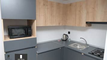 Quarto Duplo Deluxe | Cozinha privada | Um frigorífico no espaço comum, um micro-ondas, uma placa de cozinha