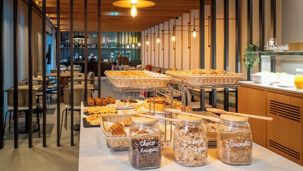 Uma área de buffet com diversos alimentos e potes identificados com nomes como 'Checco Krupies' e 'Fleces Integrales'.