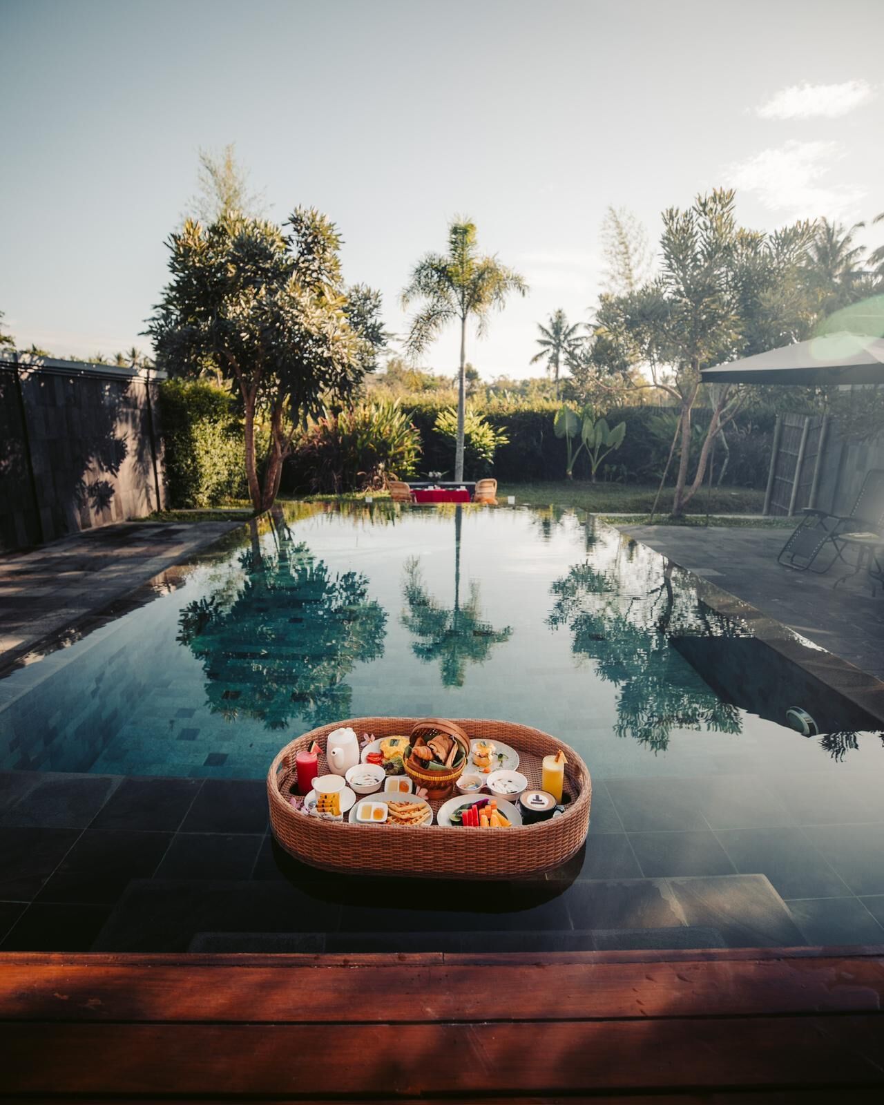 Uma área à beira da piscina com um espaço de refeições flutuante.