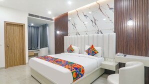 Quarto moderno com uma cama grande, uma mesinha de cabeceira e um espelho.