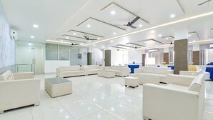 Um hall amplo com mobiliário moderno, iluminação embutida e uma parede de vidro.