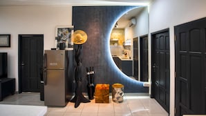 Uma cozinha moderna com parede curva, geladeira, mesa de jantar e um vaso.
