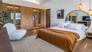 Quarto moderno com cama grande, guarda-roupa de madeira e claraboia.