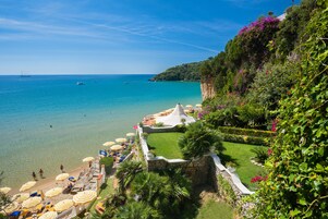 Praia particular, areia branca, espreguiçadeiras, guarda-sóis 