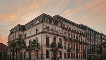 Um hotel de vários andares com estilo arquitetônico clássico, com varandas e uma entrada central.