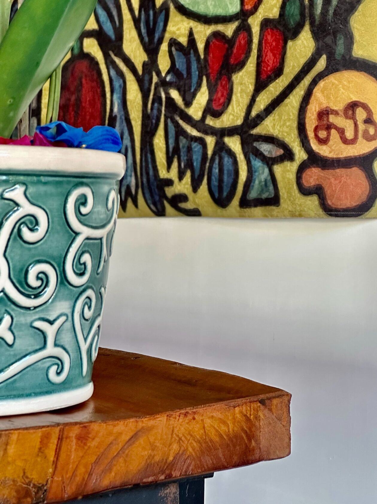 Um vaso de cerâmica com um desenho azul e branco, sobre uma superfície de madeira.