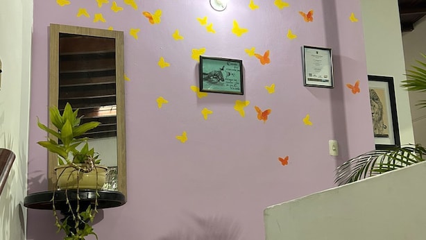 Uma escada com uma parede roxa, um quadro emoldurado e um vaso de planta.