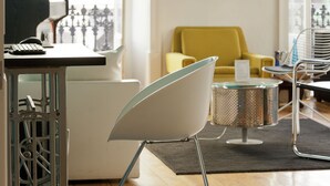 Uma sala de estar moderna com um sofá amarelo, um crânio de alce fixado na parede, um piano e um tapete azul.