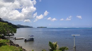 Uma baía calma com barcos atracados, céu claro e uma ilha ao longe.