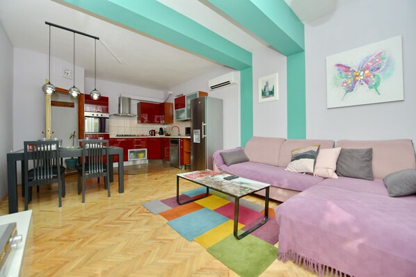 Uma sala de estar moderna com sofá, mesa de centro e área de jantar.