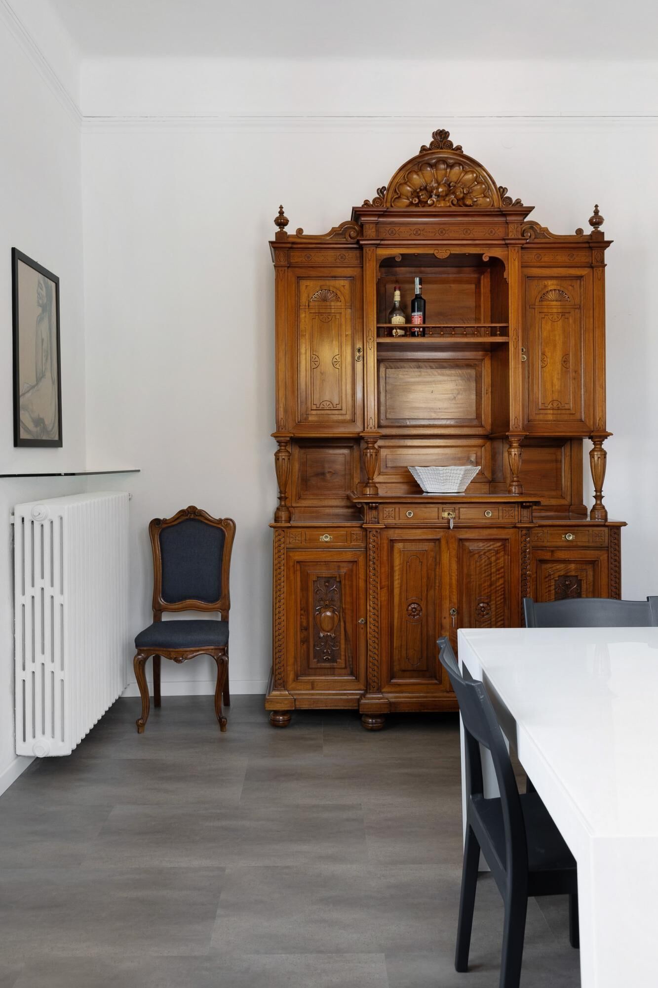 Uma área de refeições com um armário de madeira, uma cadeira e uma mesa.