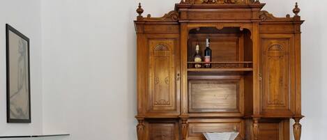 Uma área de refeições com um armário de madeira, uma cadeira e uma mesa.