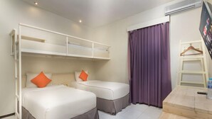 Quarto de hotel com duas camas, uma escrivaninha e uma televisão.