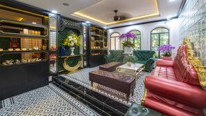 Um interior luxuoso com um sofá de couro vermelho, poltronas verdes e um piso estampado.