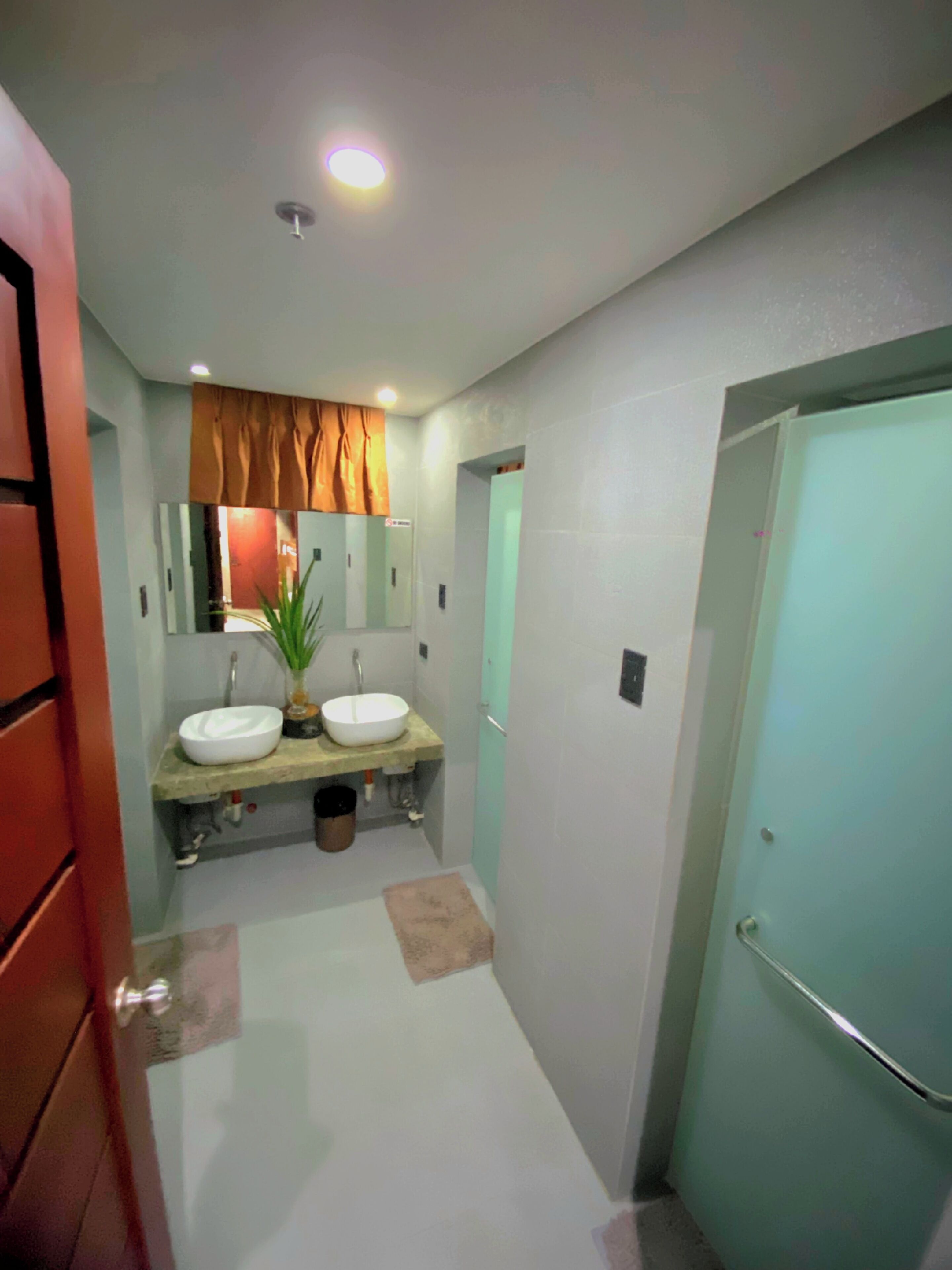 Uma casa de banho moderna com duas pias, um espelho e um porta-toalhas.