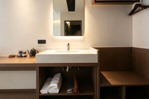 Uma casa de banho moderna com uma sanita branca, um espelho e um porta-toalhas.