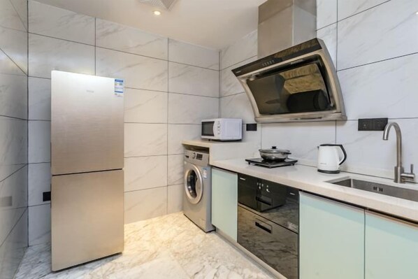 Uma cozinha moderna com micro-ondas, forno e lava-louças embutidos.