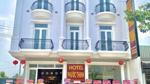 Um hotel com estilo arquitetônico clássico, com várias varandas e uma placa visível indicando que é um hotel.