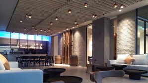 Uma área de estar moderna com um bar, assentos e uma parede de pedra.