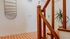 Uma escadaria com corrimãos de madeira e piso xadrez.