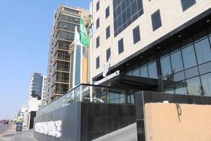Um edifício moderno com fachada de vidro e uma placa com a inscrição 'RESIDENCE'.