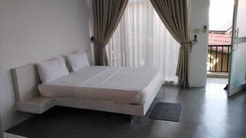 Um quarto com uma cama, um banco e vista para o exterior.
