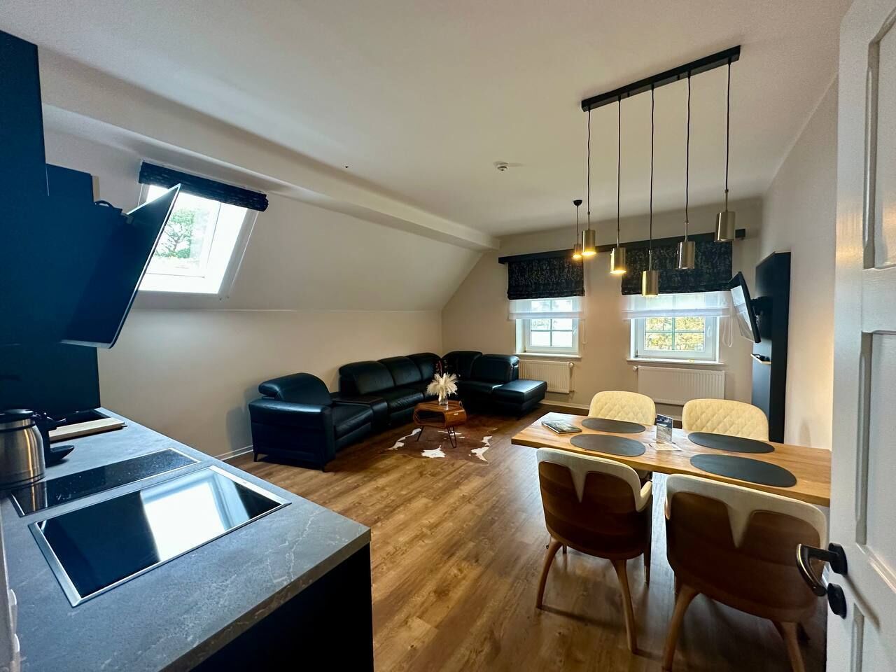 Um loft moderno com sala de jantar, cozinha e área de estar.