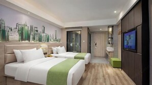 Quarto de hotel com duas camas, um mural da paisagem urbana, uma televisão e um banheiro.