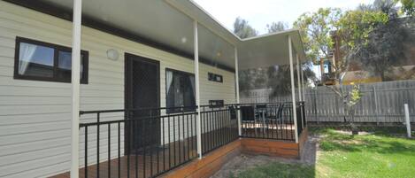 Uma casa móvel térrea com varanda coberta e quintal cercado.