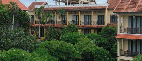 Um hotel com edifícios de vários andares, piscina e vegetação exuberante.