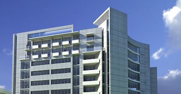 Um edifício moderno de vários andares, com varandas e grandes janelas.