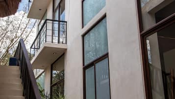 Um edifício com vários andares, escadas, janelas amplas e varandas.