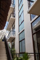 Um edifício com vários andares, escadas, janelas amplas e varandas.