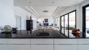 Cozinha moderna com ilha central, área de refeições com vista e uma janela ampla.