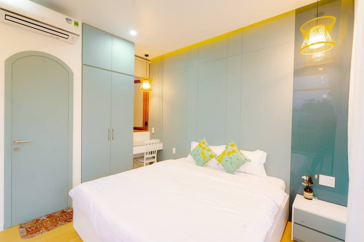 Quarto com cama, mesa de cabeceira, armário e espelho.