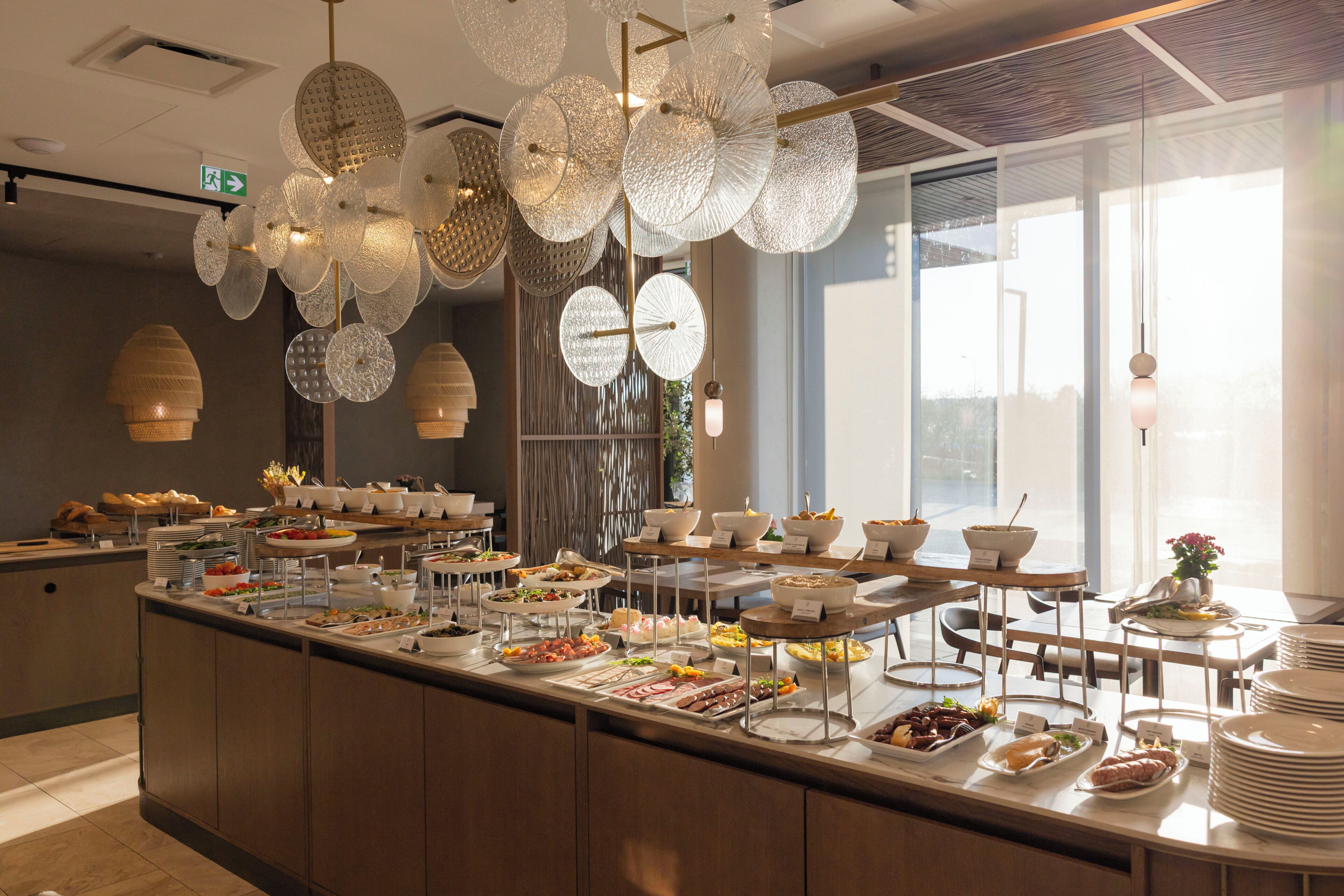 Disposição de buffet com diversos alimentos e decoração de interiores moderna.