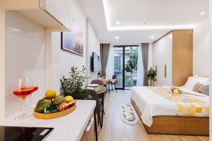 Quarto de hotel moderno com cama, área de refeições e vista para o exterior.