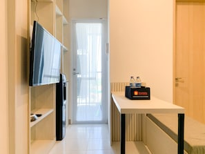 Quarto de hotel com televisão de tela plana, bebedouro e minibar.