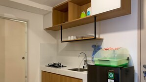 Uma cozinha compacta com fogão a gás, pia e geladeira.