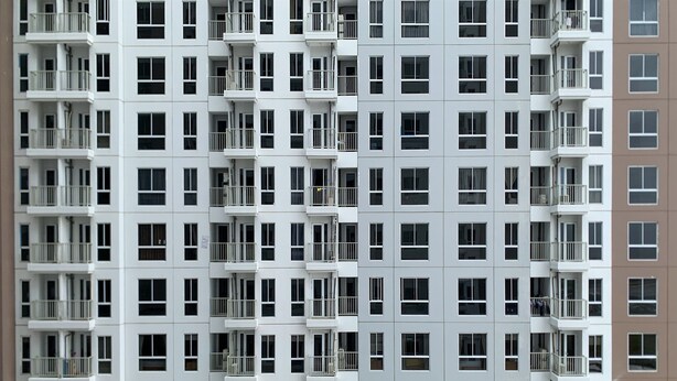 Edifício residencial com vários andares, fachada uniforme, varandas e janelas regularmente espaçadas.