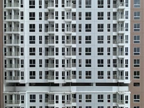 Edifício residencial com vários andares, fachada uniforme, varandas e janelas regularmente espaçadas.