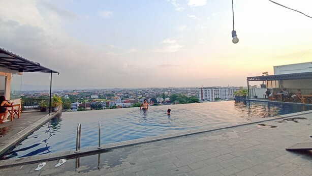 Piscina no terraço com vista para a paisagem urbana.