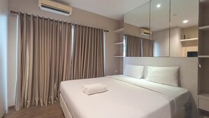 Quarto de hotel com uma cama grande, um espelho e um guarda-roupa.