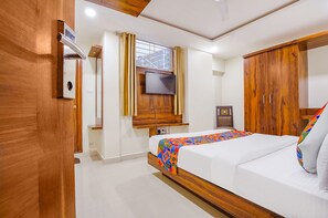 Quarto moderno com estrutura de cama de madeira, TV montada na parede e guarda-roupa.