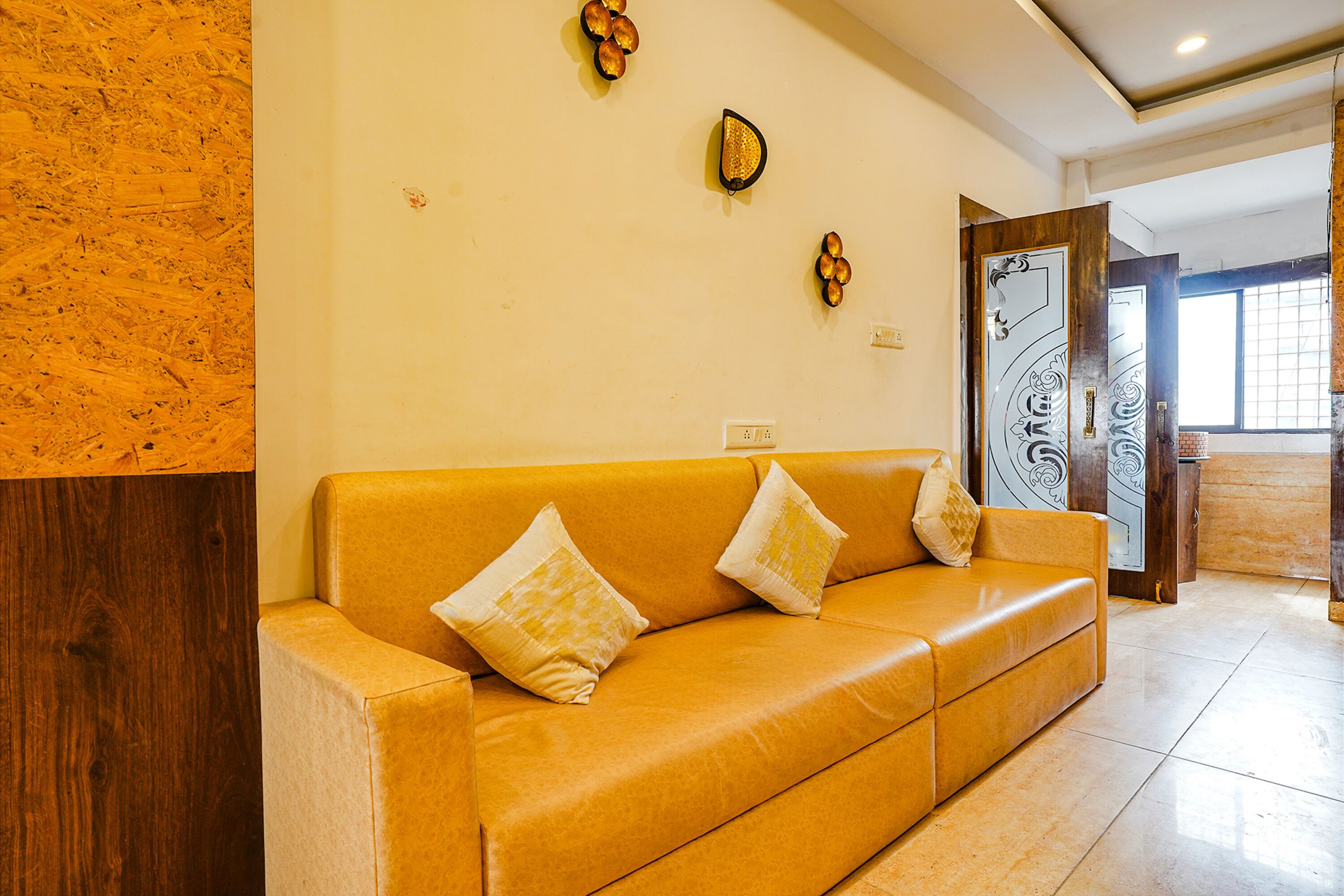 Uma sala de estar moderna com um sofá amarelo, arte decorativa nas paredes e uma parede de destaque em madeira.