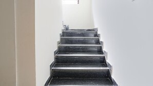 Uma escadaria com degraus pretos que levam a um patamar.